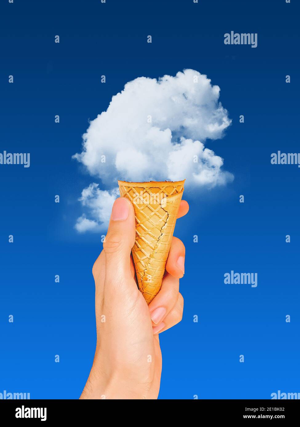 Hand holding cloud ice cream on blue background Stock Photo - Alamy
