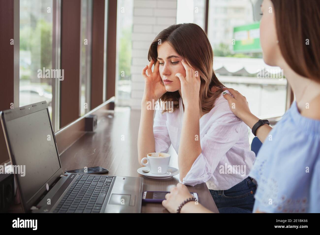 Unrecognizable woman comforting her depressed friend at the coffee shop ...