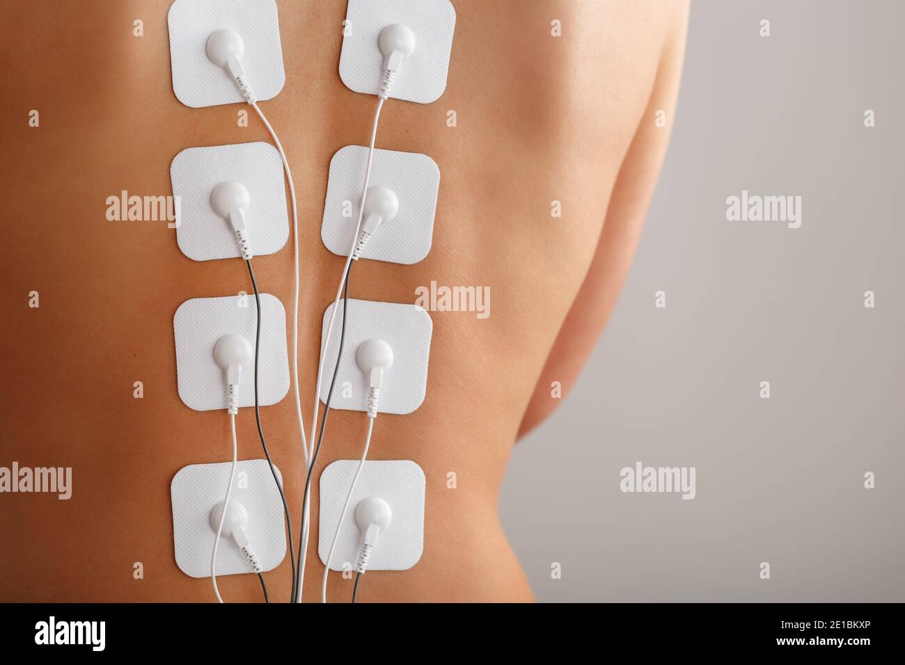 Back and shoulder massage with a muscle stimulator with attached ...