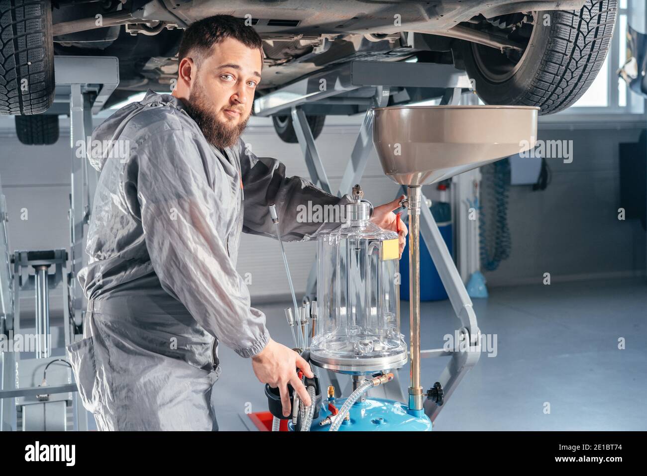 Car Mechanic Replacing Oil in Motor Engine. Auto service shop Stock ...