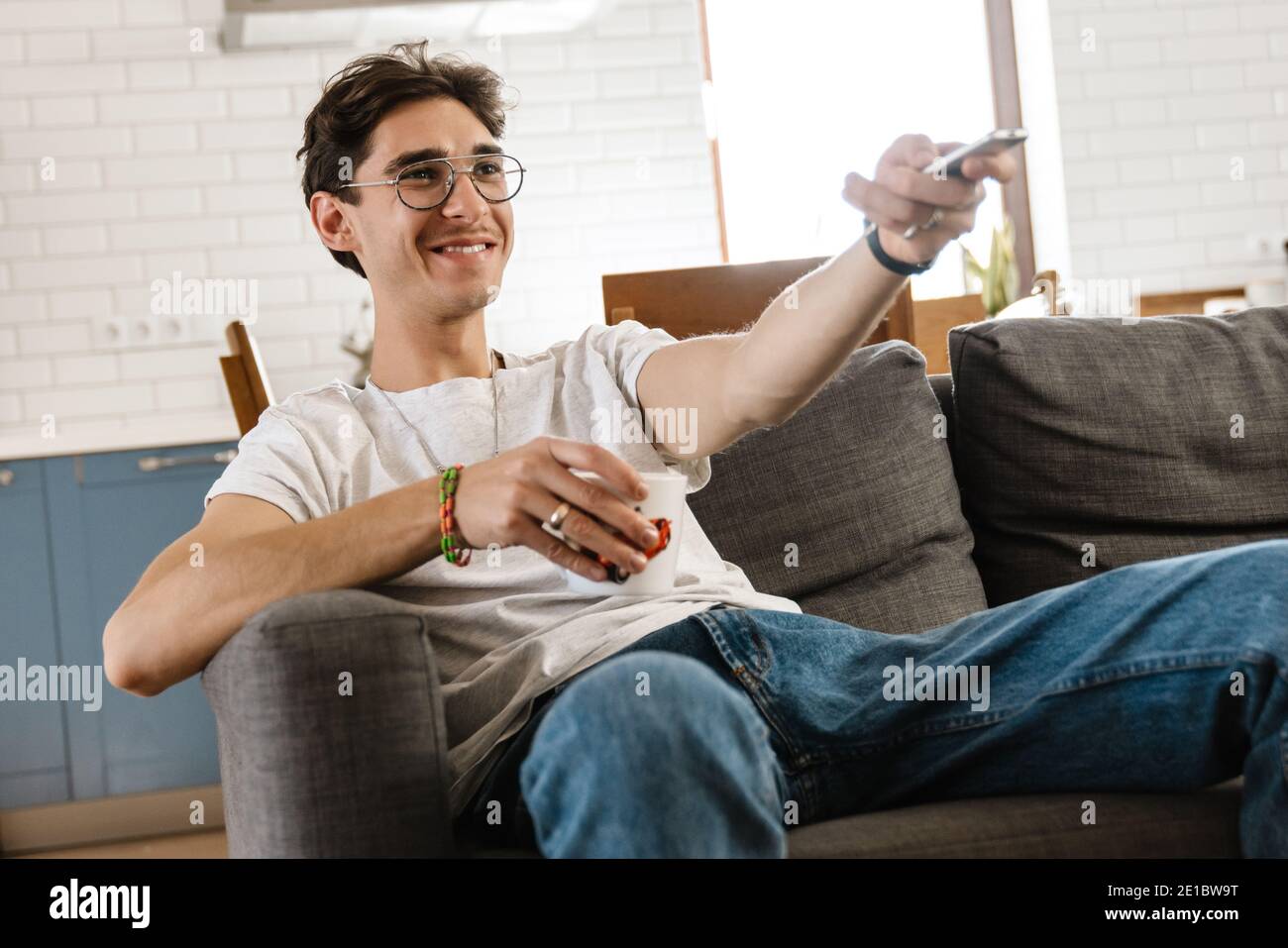 Man watching tv drinking coffee hi-res stock photography and images - Alamy
