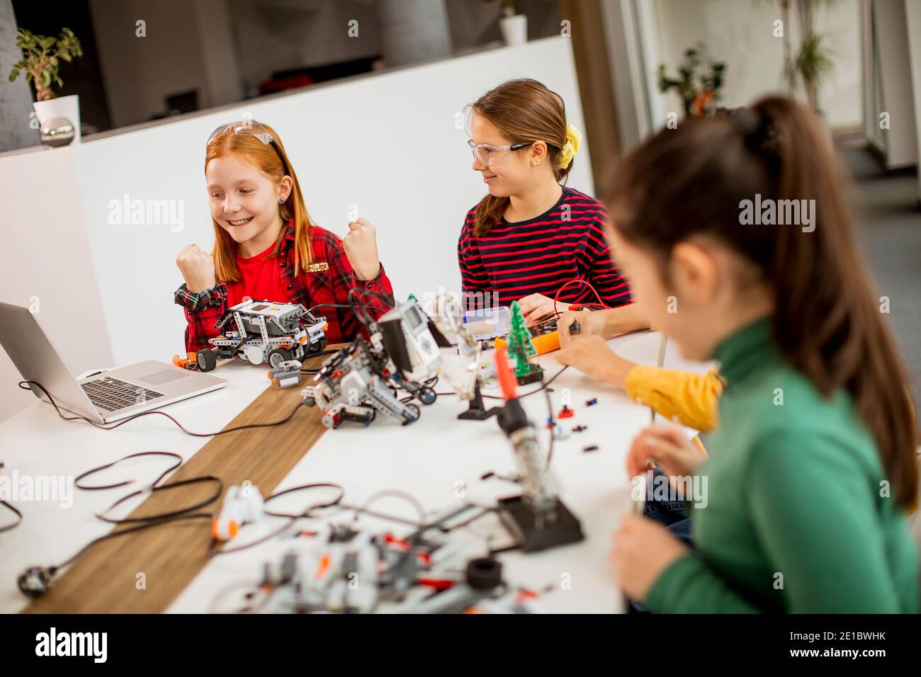 Group of happy kids programming electric toys and robots at robotics ...