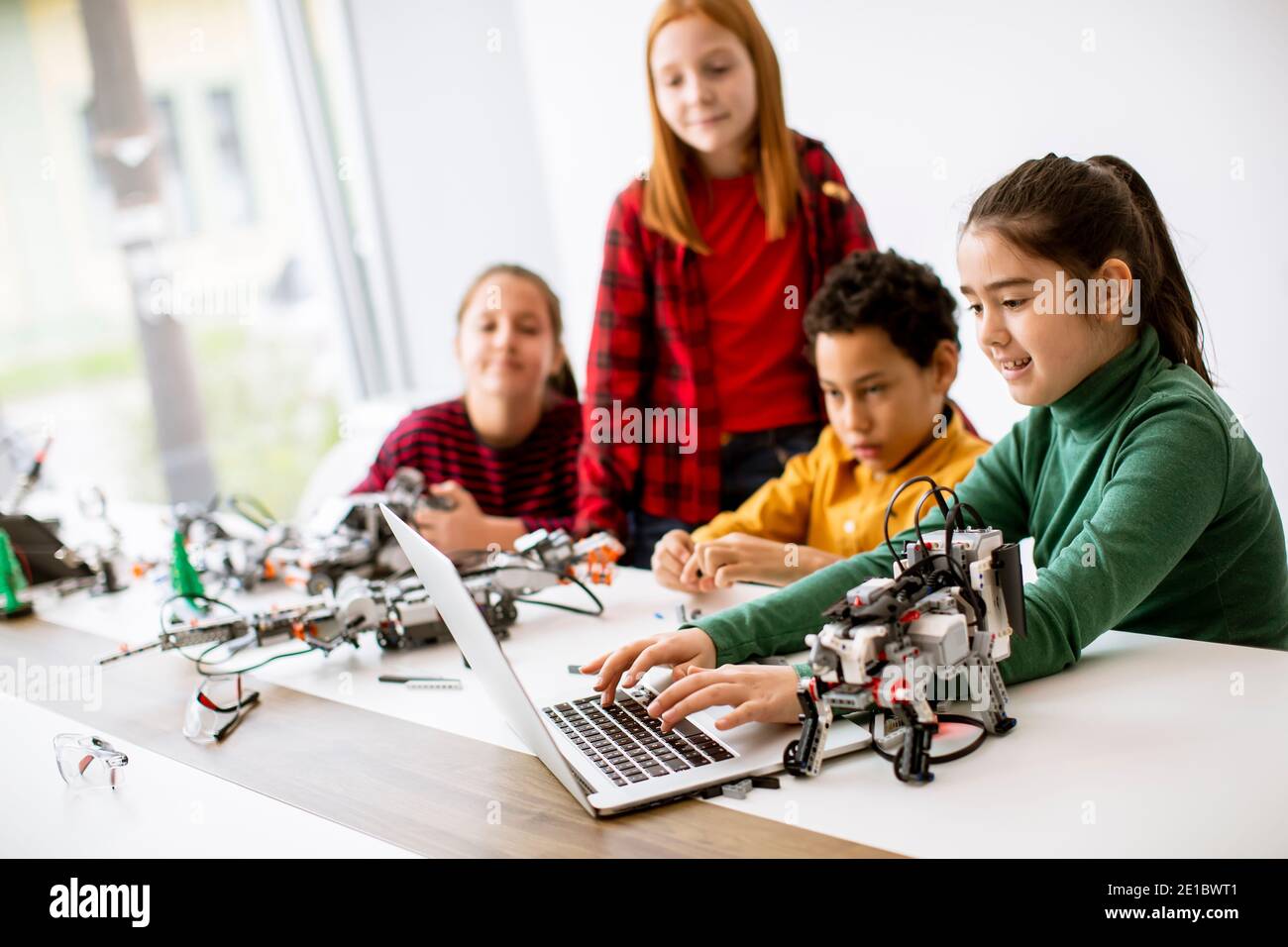 Group of happy kids programming electric toys and robots at robotics ...