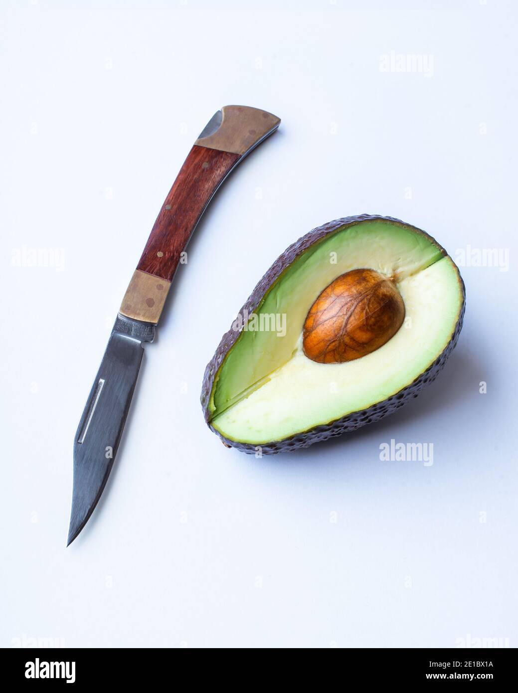 Sliced avocado and knife isolated on white background. Cut and open ...