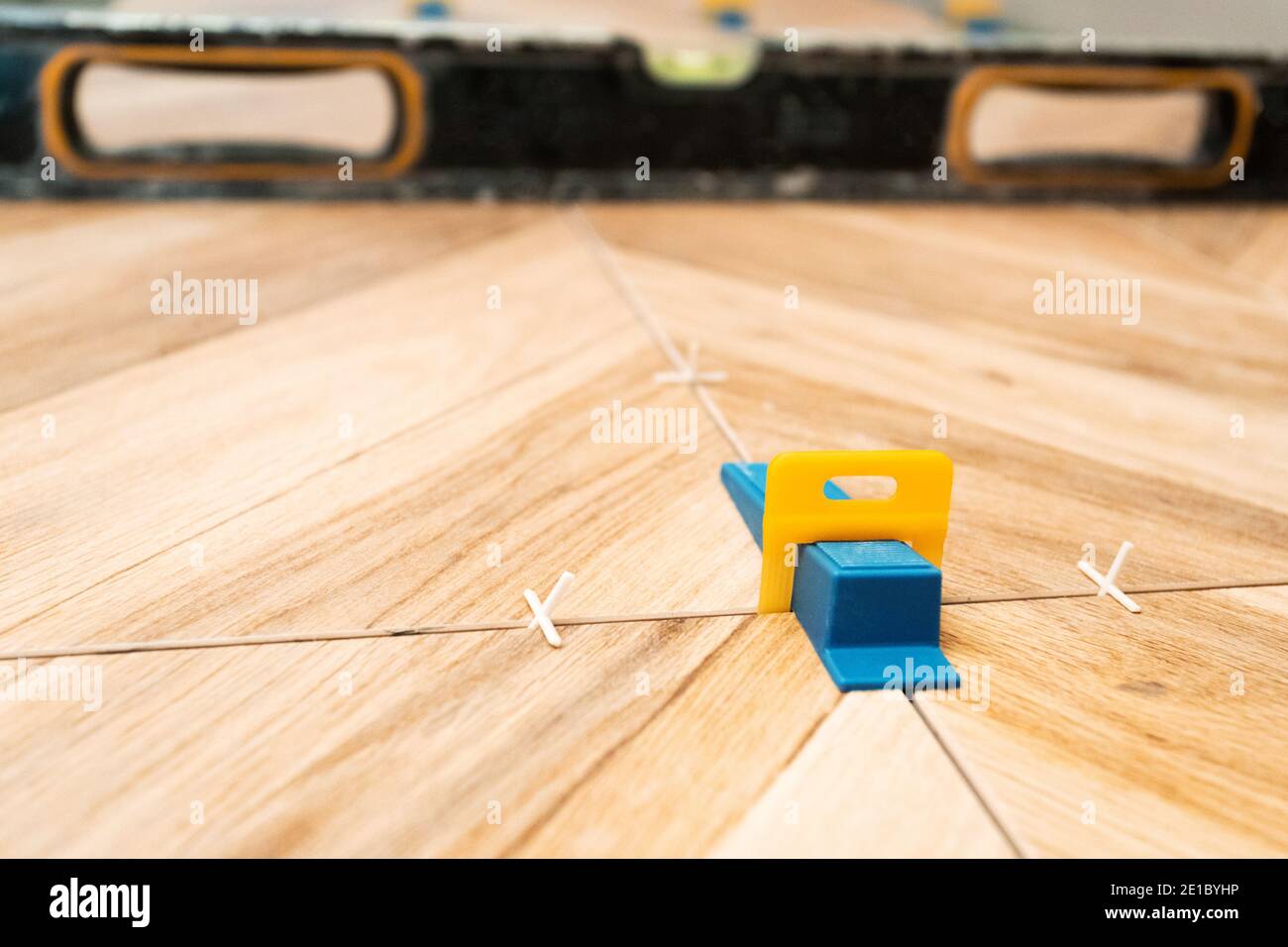 Tiling work. The man checks the level of the correct laying of the ...