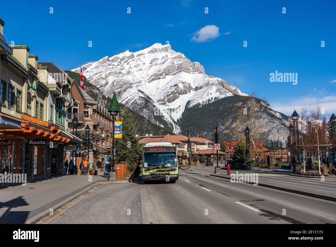 Banff Avenue bus stop, street view of Town of Banff. Snow capped Cascade Mountain in the ...