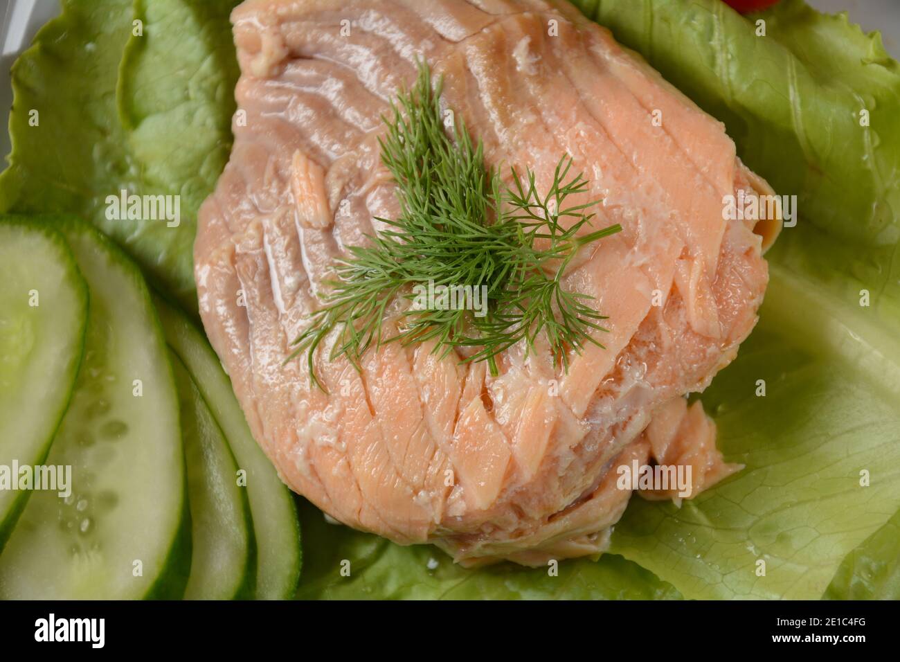 Canned salmon chunks with lettuce leaves,on white plate Stock Photo - Alamy