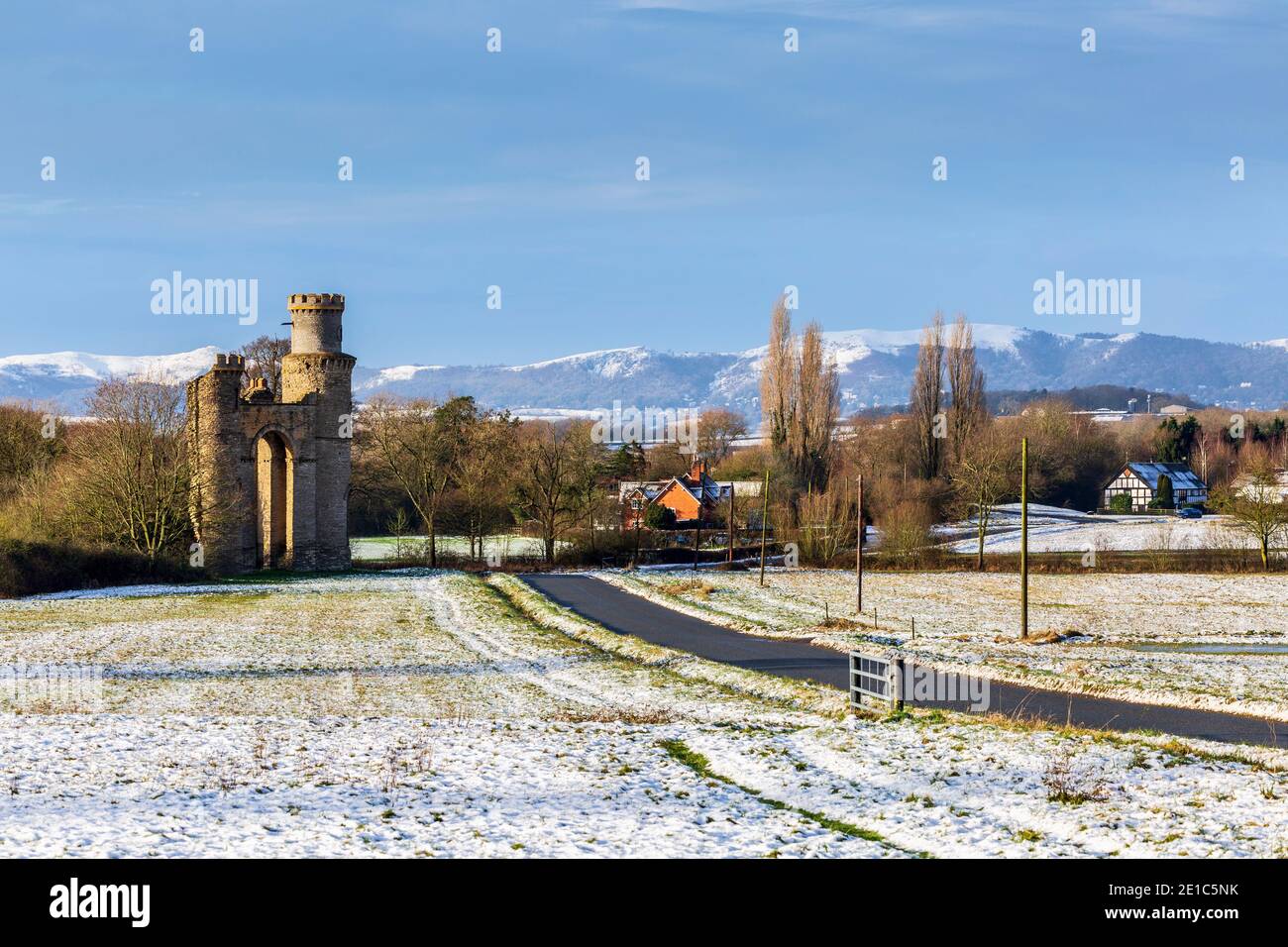 Snow covered Dunstall Common and Castle with the Malvern hills in the ...