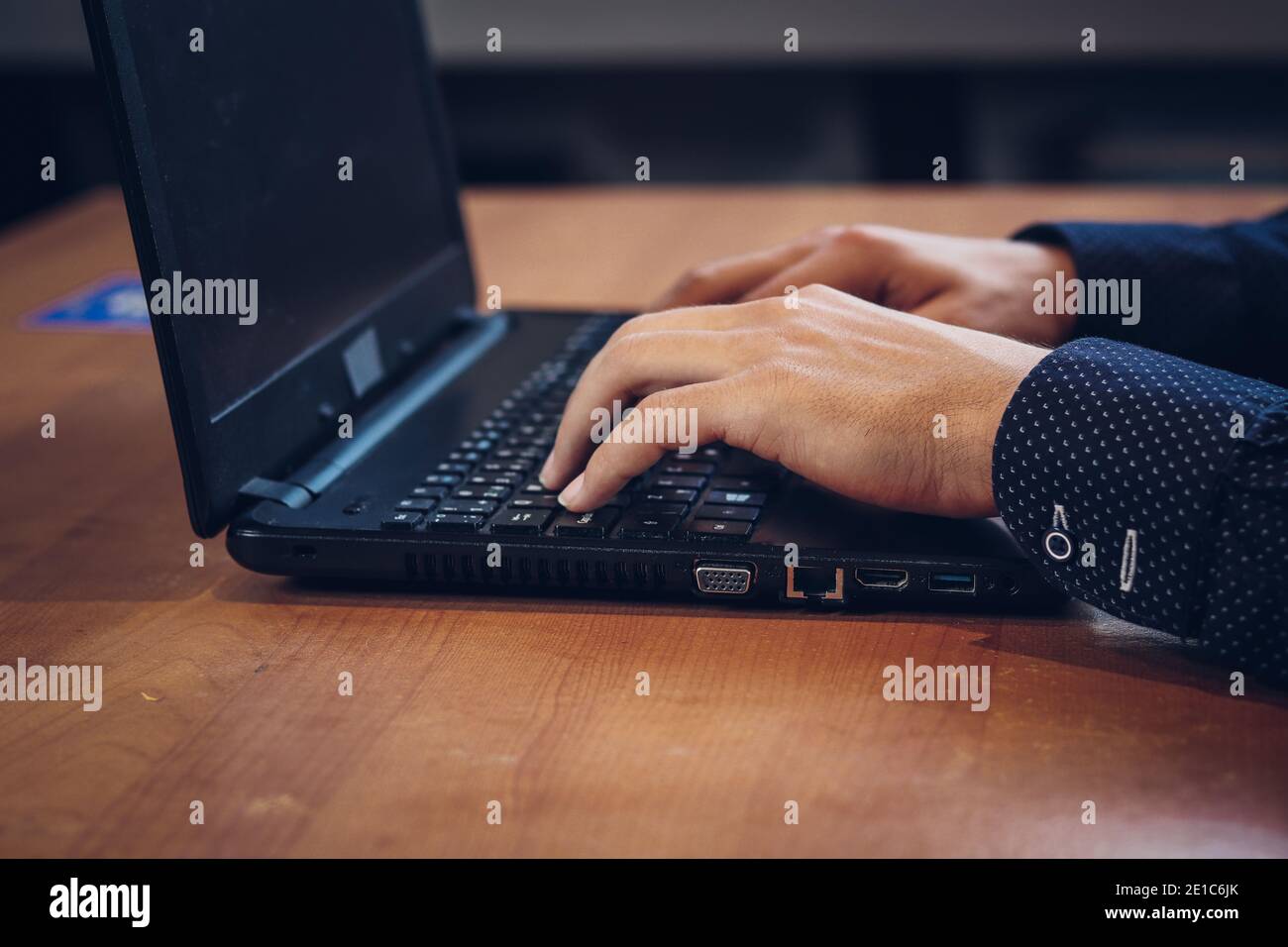 young man turns on his computer and starts typing his novel on the ...