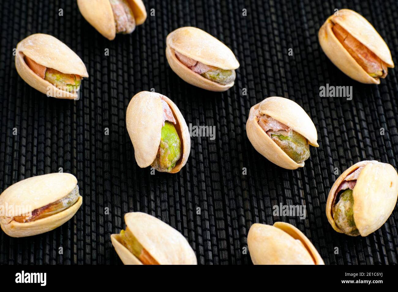 Some Pistachio nuts on black napkin background Stock Photo - Alamy