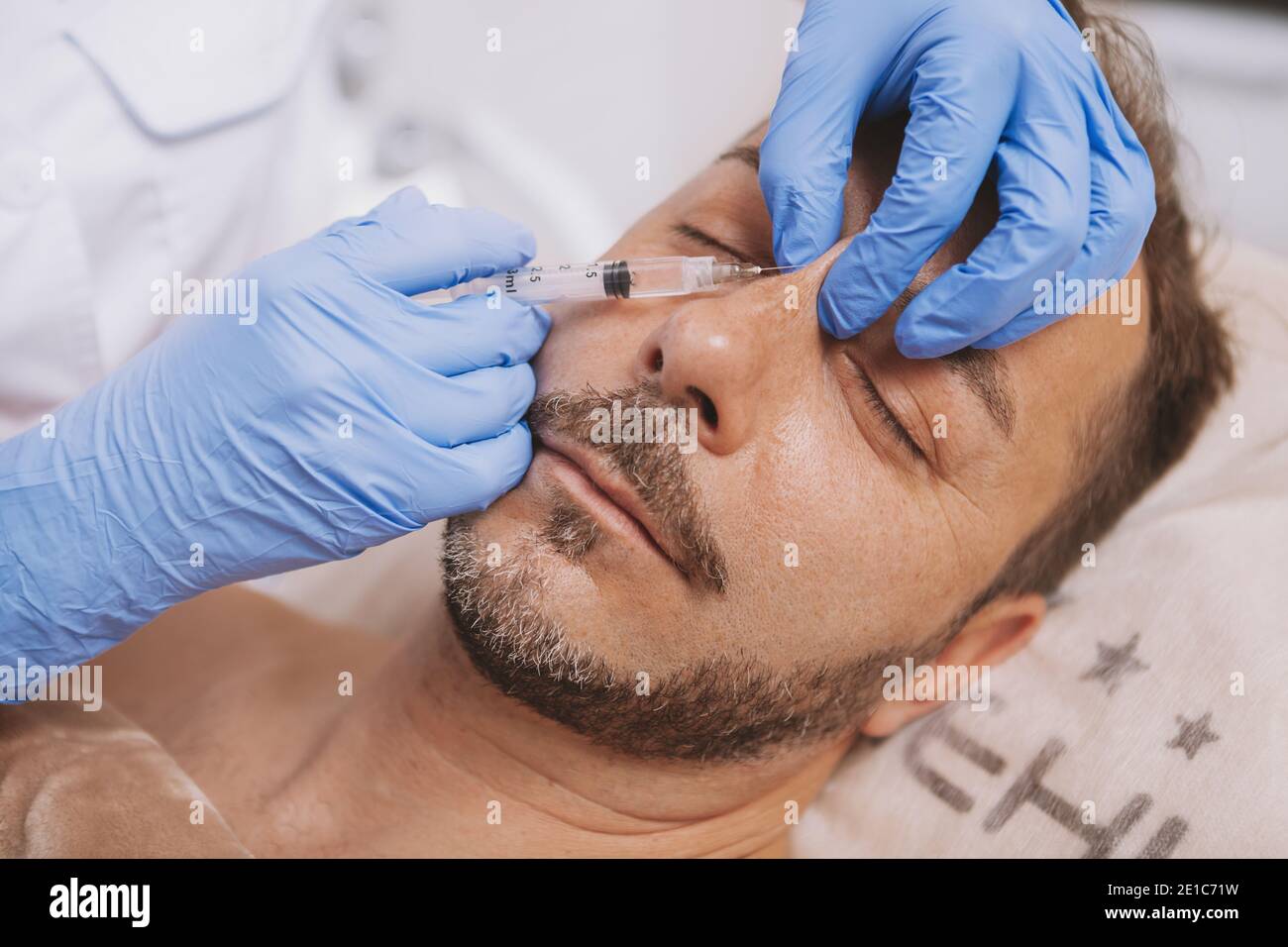 Mature man getting liquid rhinoplasty by professional cosmetologist ...