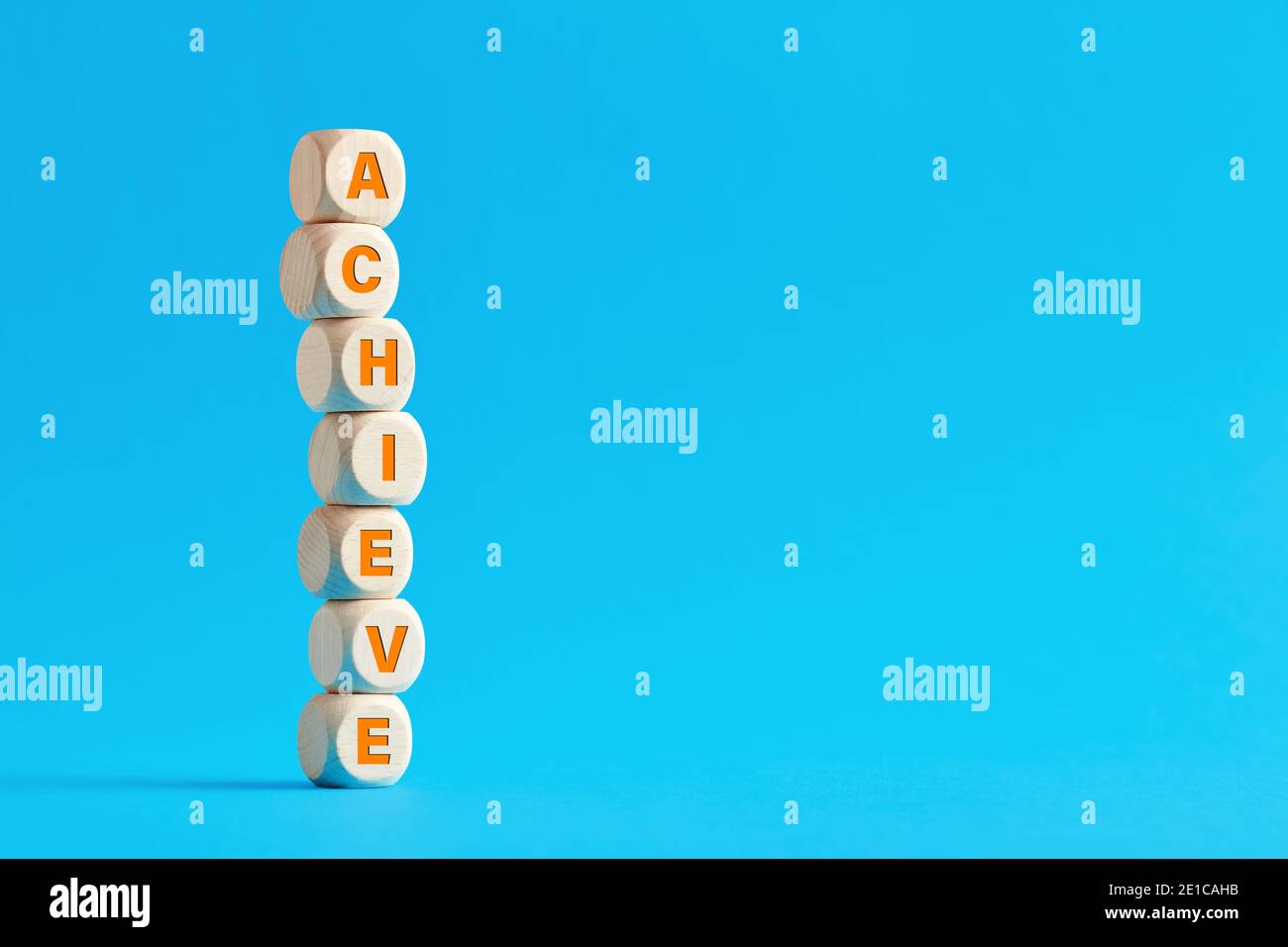 The word achieve on tiered wooden cubes on blue background. Achievement ...