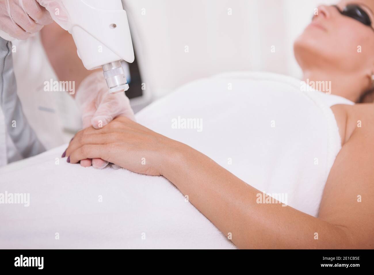 Cosmetologist removing skin discoloration on the hand of a mature woman ...