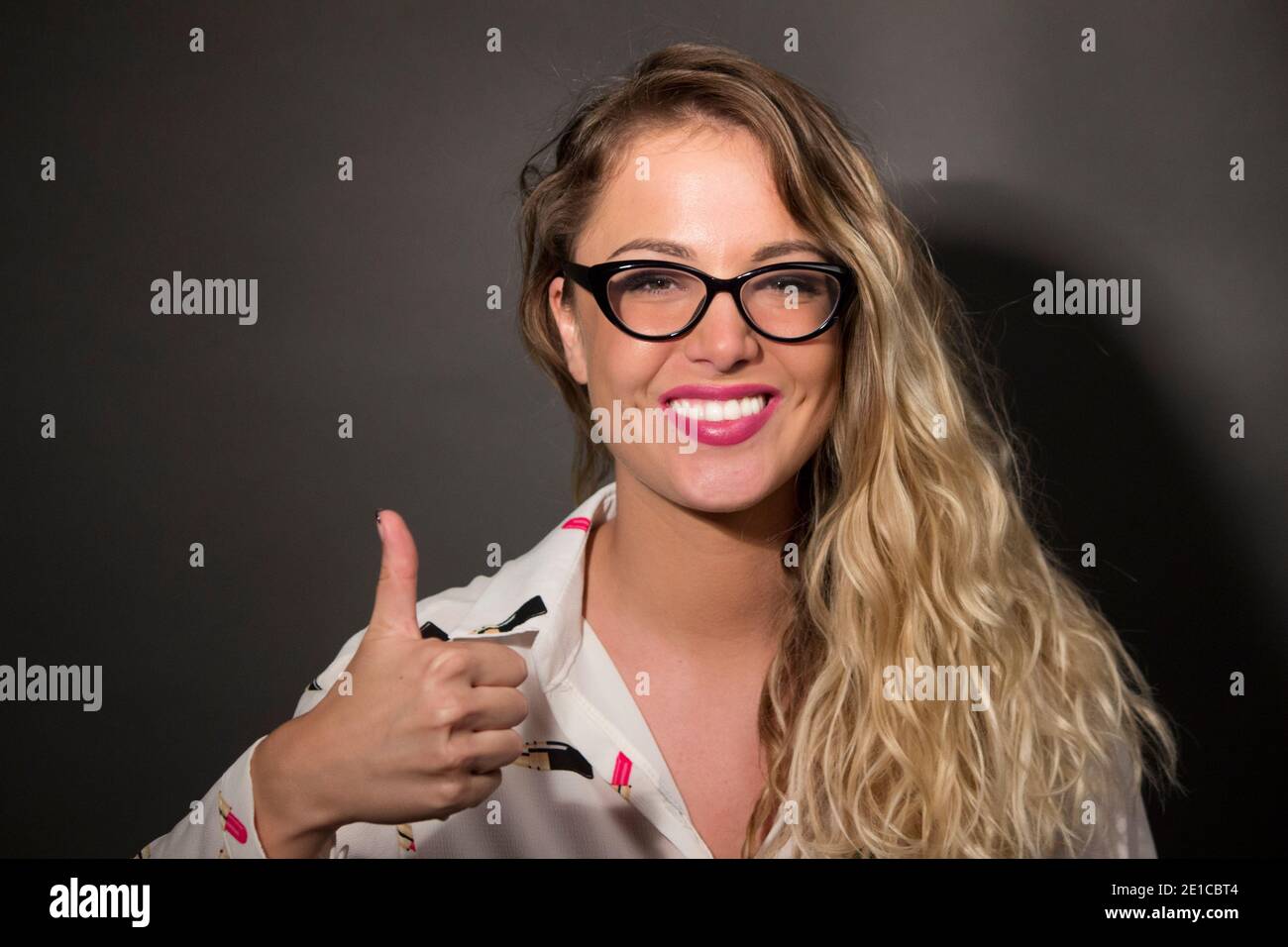 Young woman showing thumbs up sign hi-res stock photography and images ...