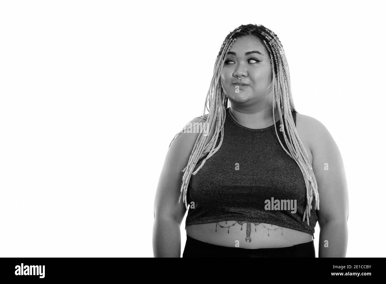 Studio shot of young fat Asian woman thinking while looking to the side ...