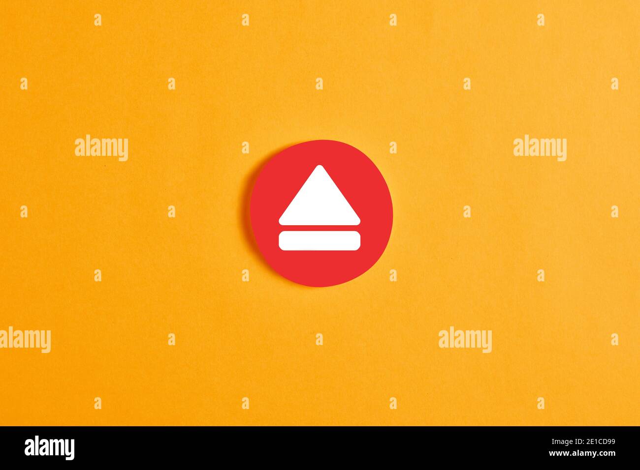 Red round circle with an eject button or icon against yellow background ...