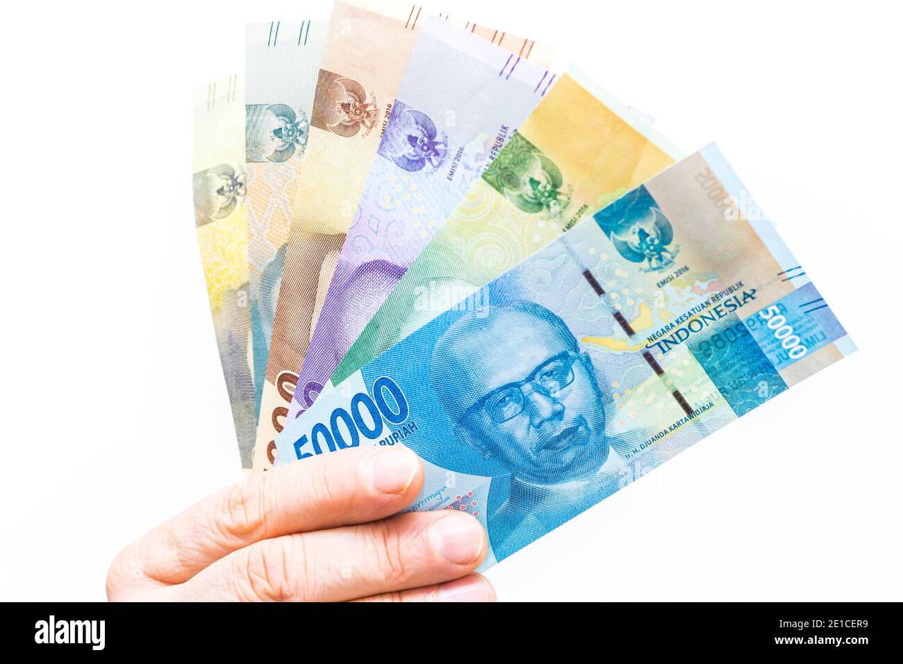 The currency of Indonesia, Rupiah, File of banknotes held in the hand ...