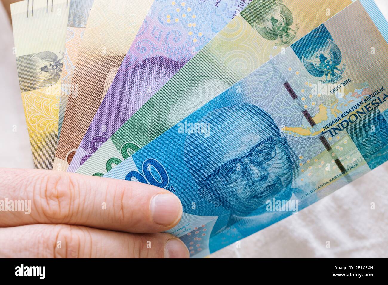 Indonesian money in your hand, various banknotes Stock Photo - Alamy