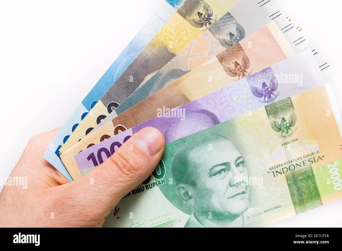 The currency of Indonesia, Rupiah, File of banknotes held in the hand ...
