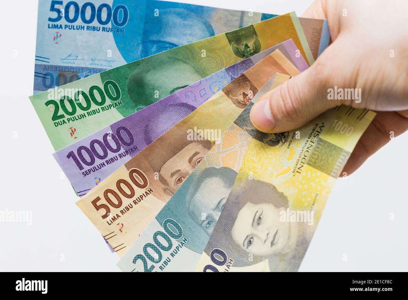 The currency of Indonesia, Rupiah, File of banknotes held in the hand ...