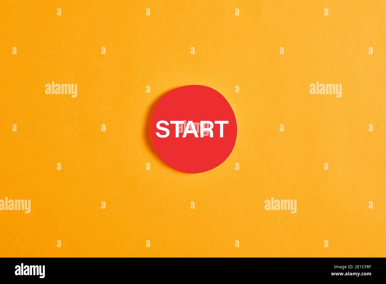 Red round button with the word start against yellow background. New ...
