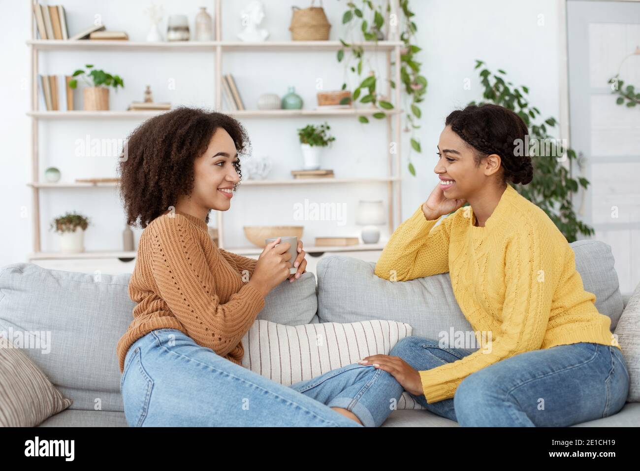 Conversation, meeting at home and friendship. Smiling young ladies ...