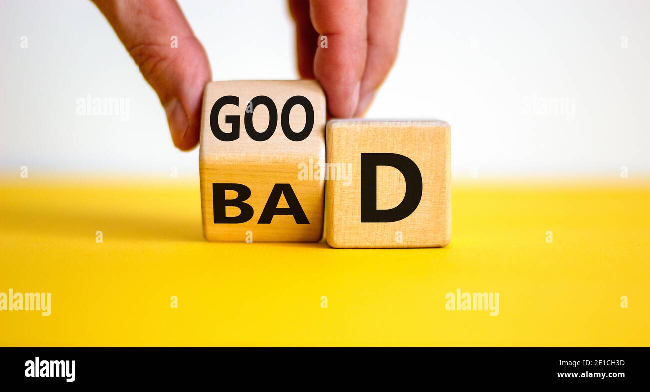 Good or bad symbol. Businessman hand turns a cube and changes the word ...