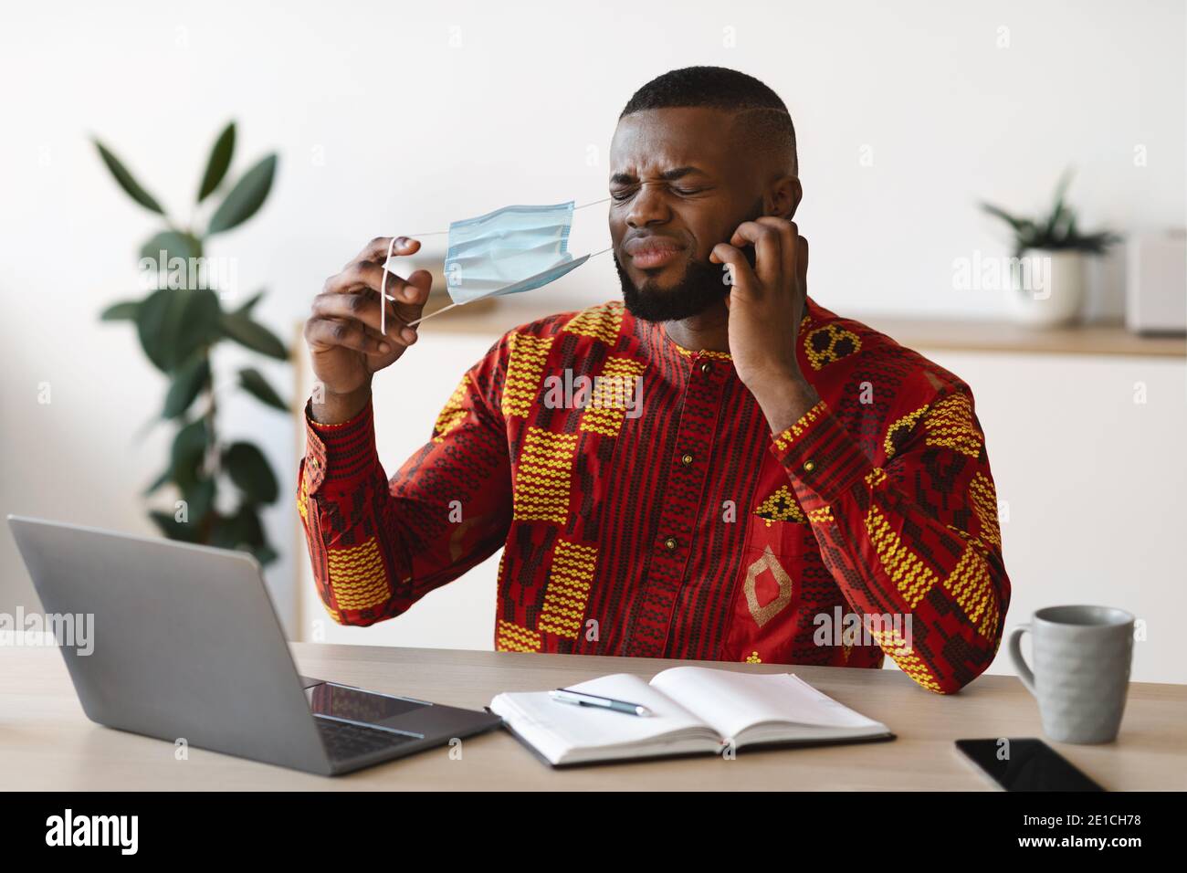 Displeased African Man Taking Off Mask At Work To Scratch Beard Stock ...