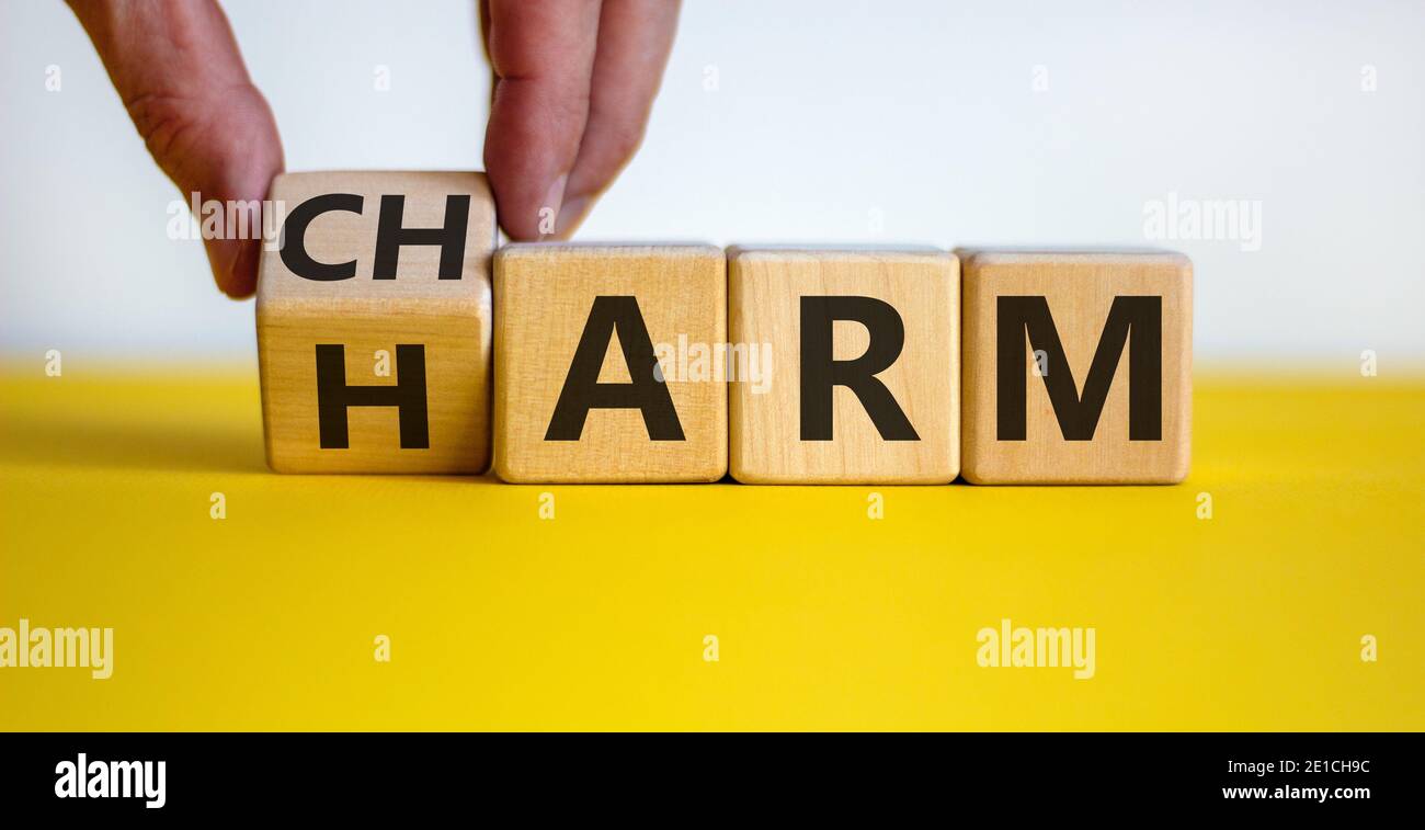 From harm to charm. Male hand turns the cube and changes word 'harm' to ...