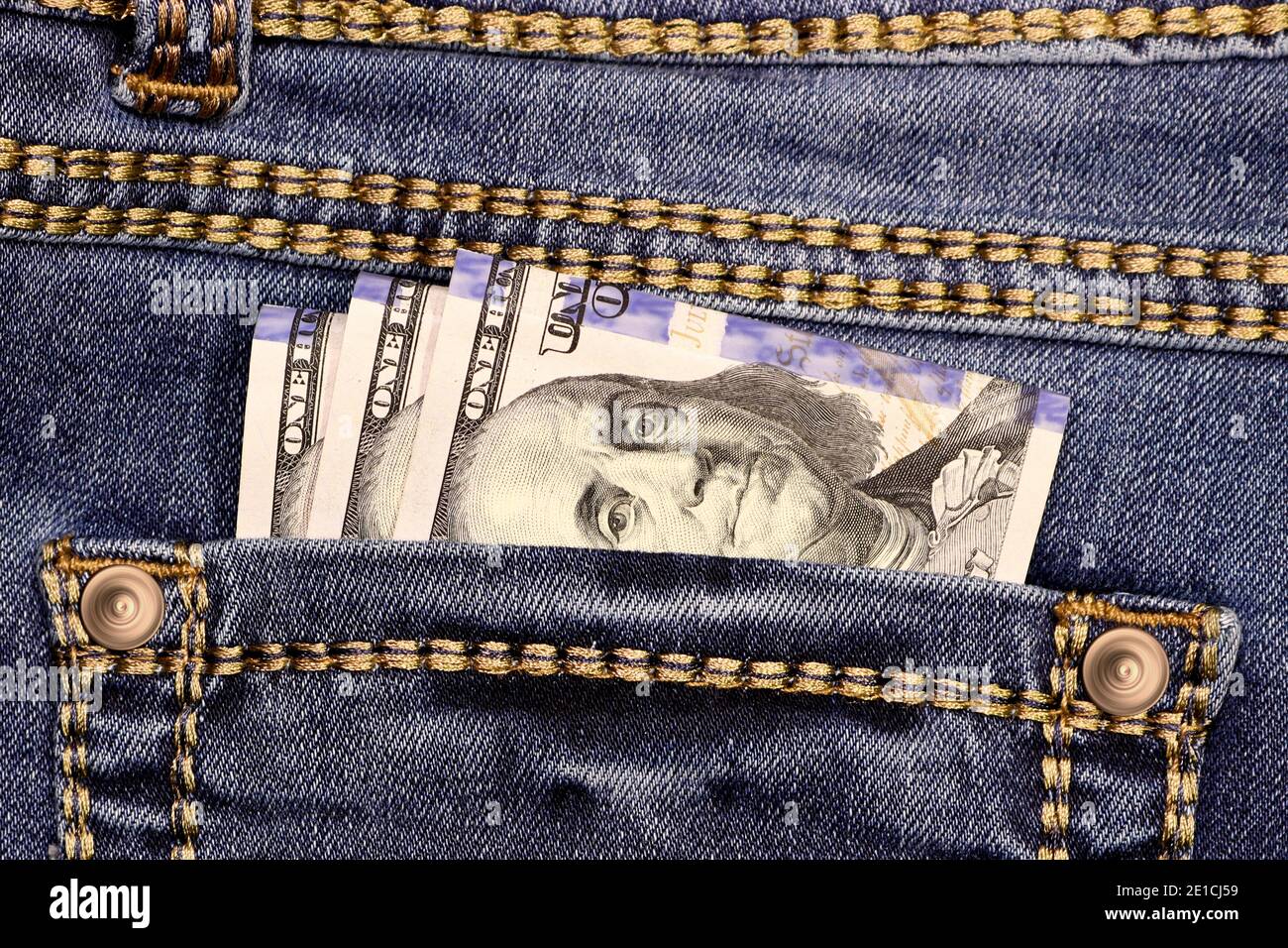 A stack of American hundred dollar bills in the back pocket of blue ...