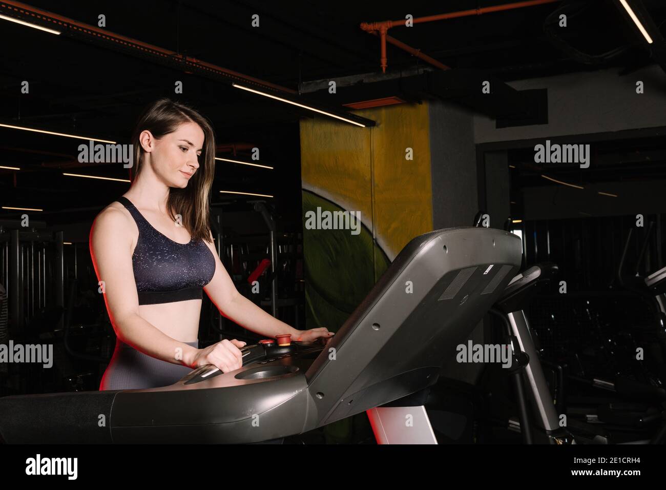 Young beautiful woman poses on the treadmill in the gym Stock Photo - Alamy
