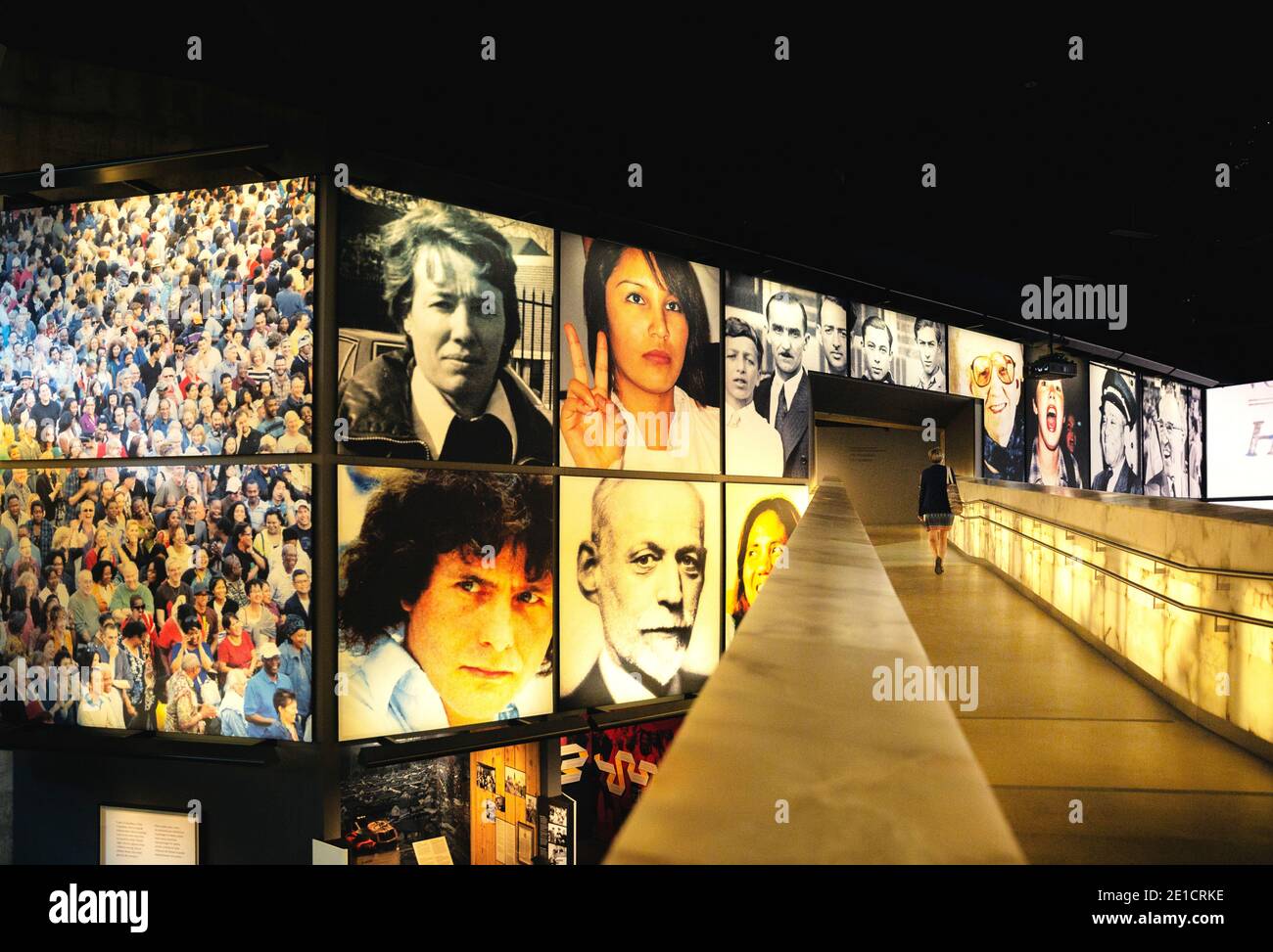 Illuminated marble bridge and woman walking over it towards the wall ...