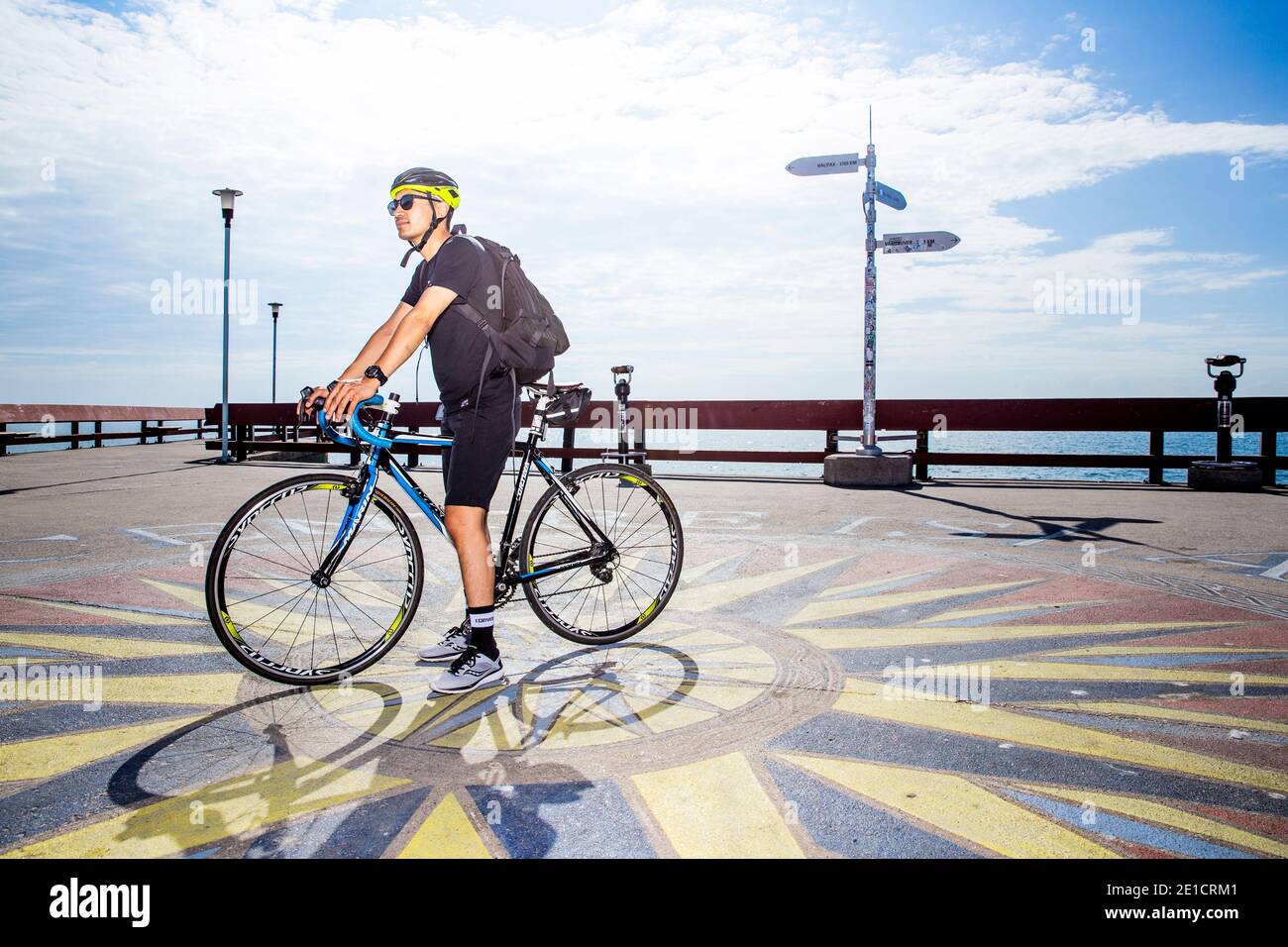 Photo of a cyclist on a bicycle standing on the Toronto Island dock and ...