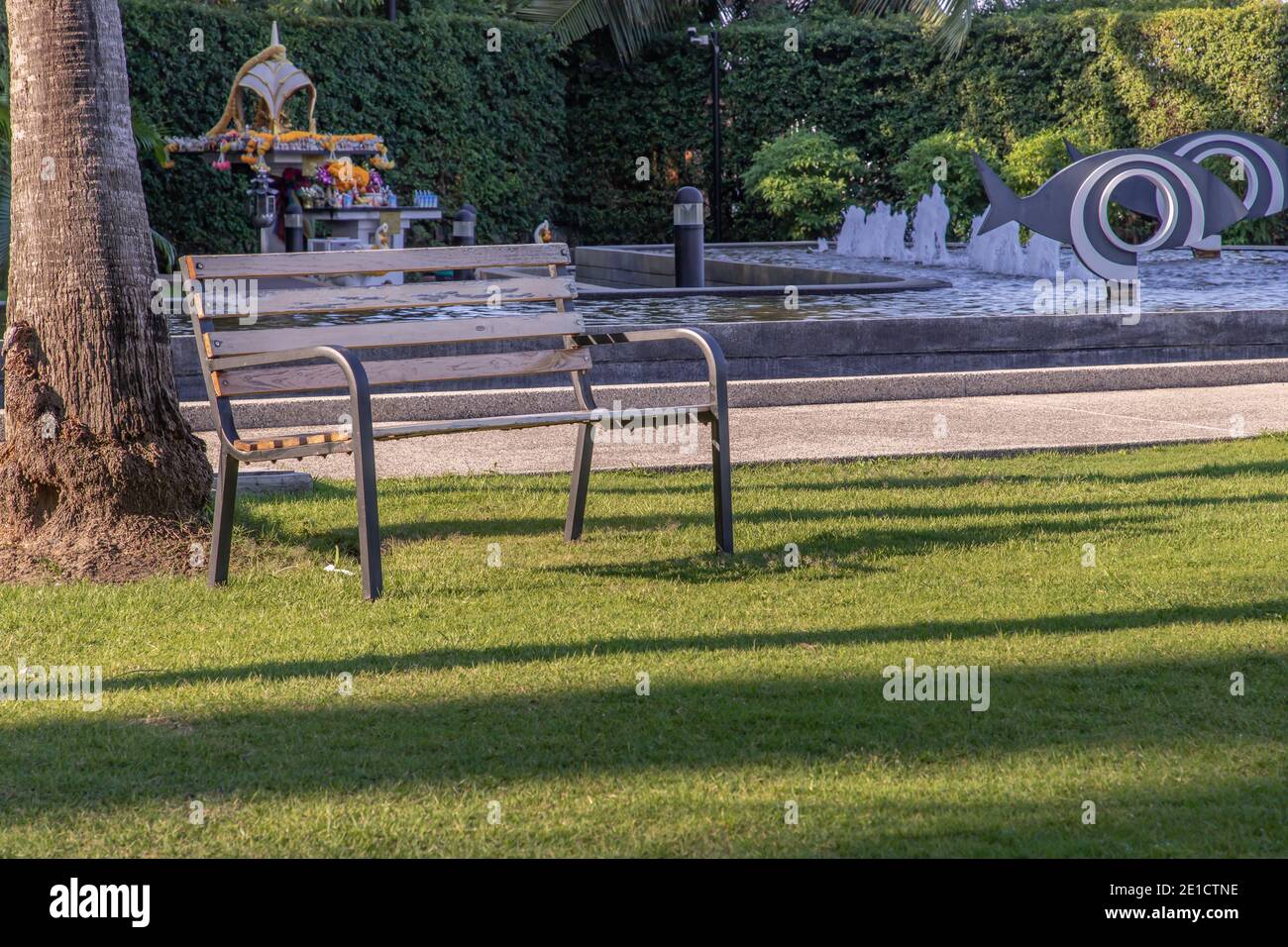 Wooden benches on grass floor in a shady area of the park. Seating and ...
