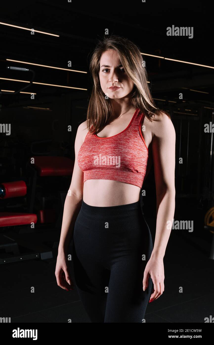 Gym poses, young beautiful woman poses standing in the gym Stock Photo ...