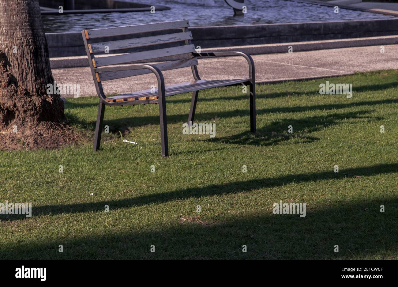 Wooden benches on grass floor in a shady area of the park. Seating and ...