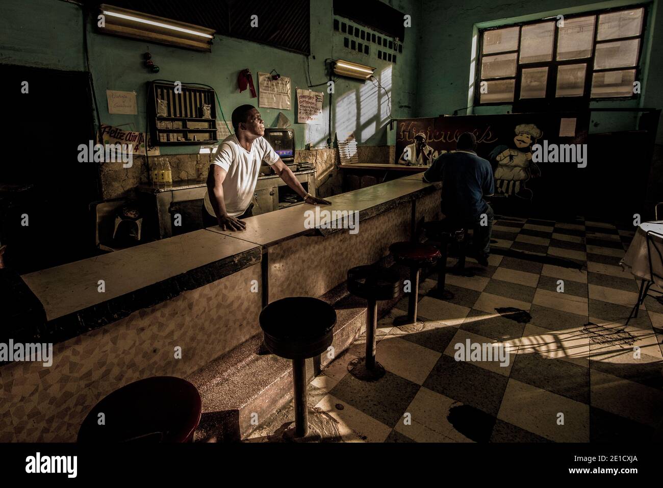 Man looks to ray of sunlight inside a vintage old bar in Havana, Cuba ...