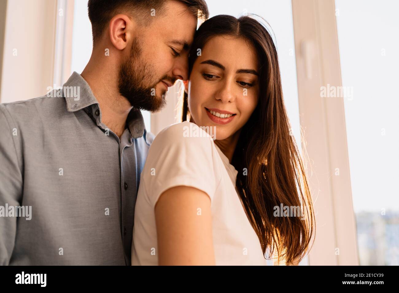 Portrait loving couples enjoying each other company with window in ...