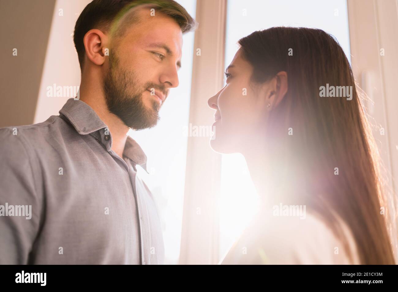 Portrait loving couples enjoying each other company with window in ...