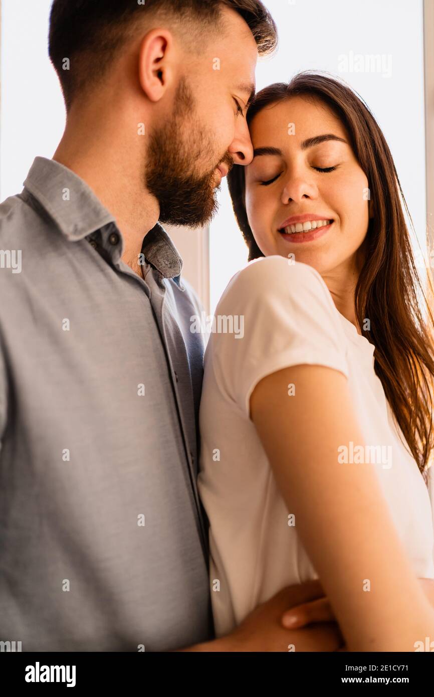 Portrait loving couples enjoying each other company with window in ...