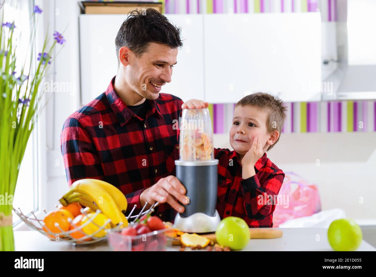 Proud young good looking father and his cute son together in kitchen ...