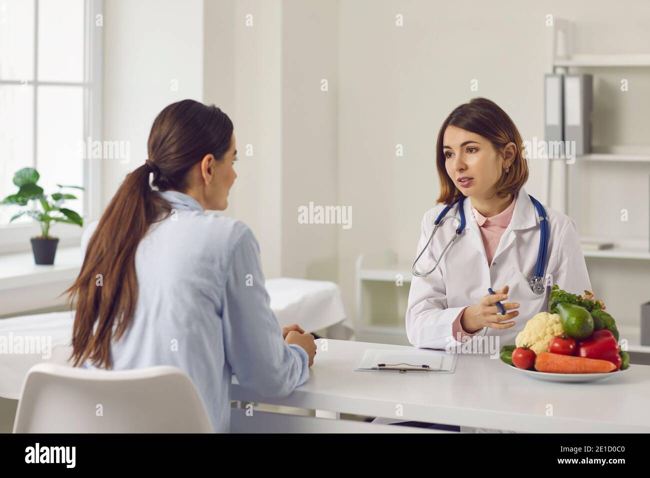 Female nutritionist makes a healthy diet plan for a patient who has ...