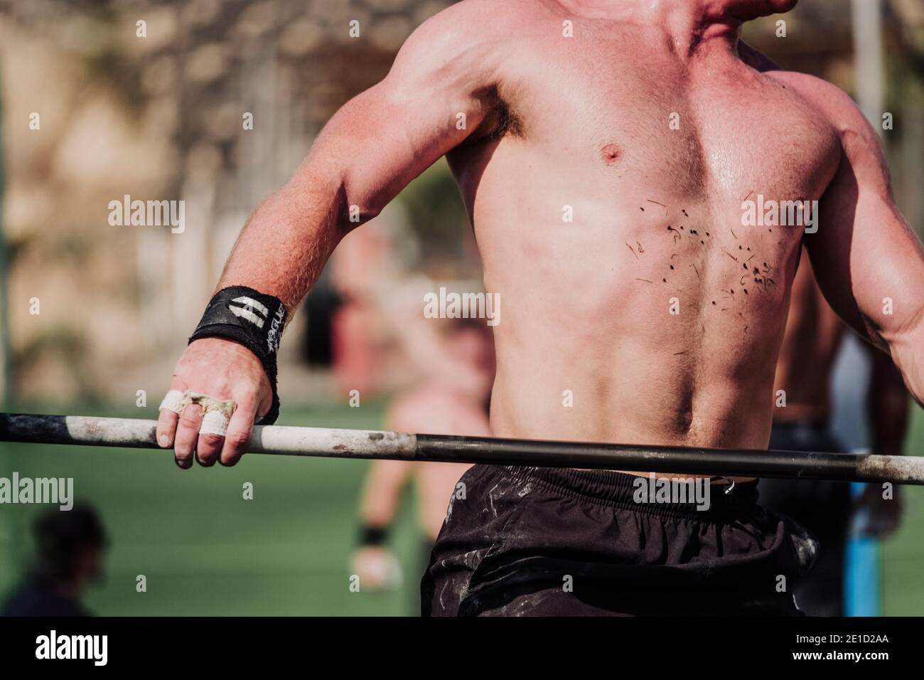 Muscular man with barbell during cross training competition Stock Photo ...