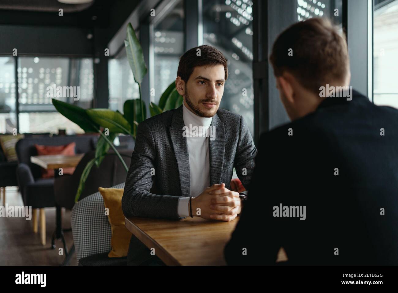 Focused businessman listening to business partner talking during ...