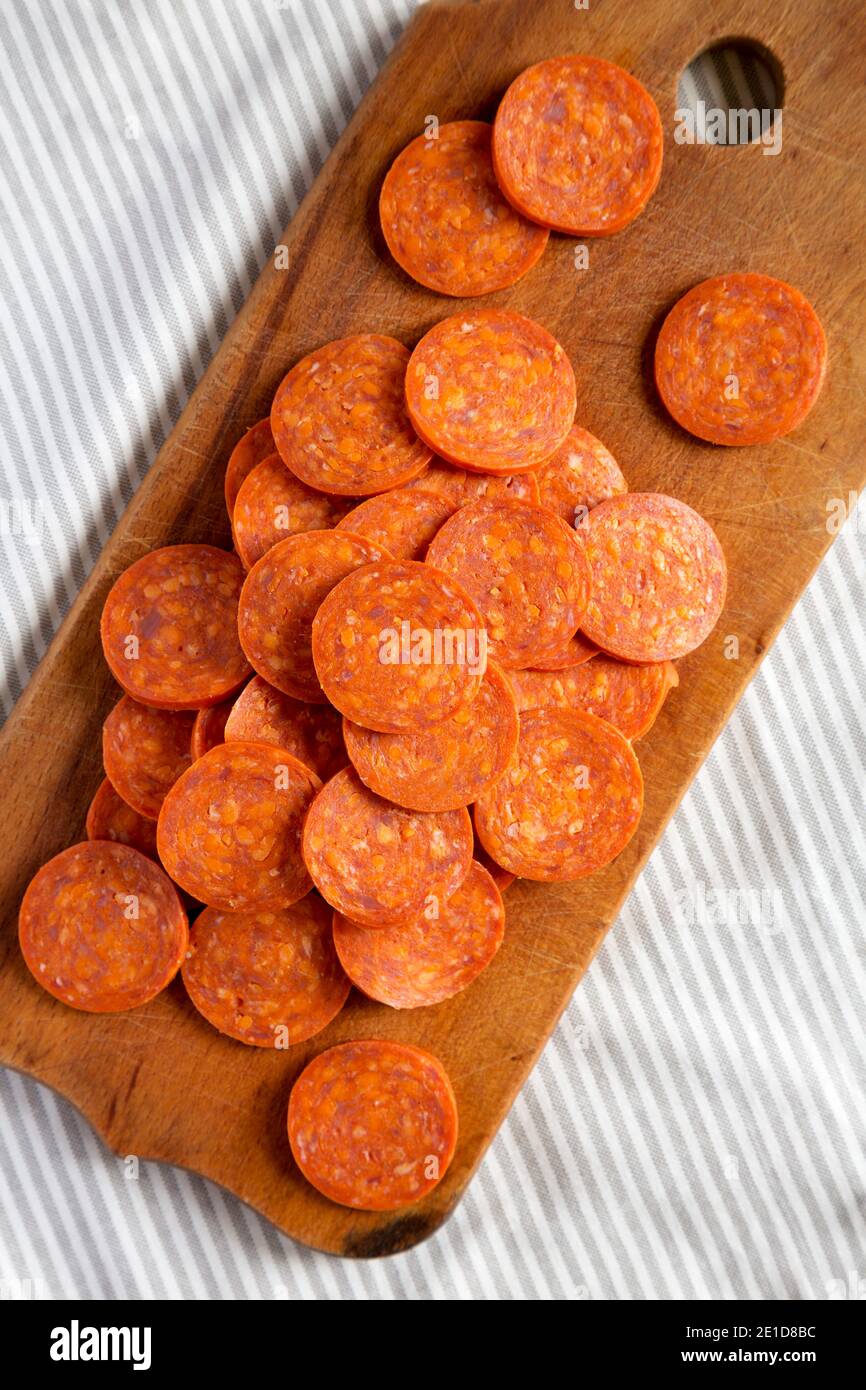 Italian Pepperoni Slices on a rustic wooden board on cloth, view from ...