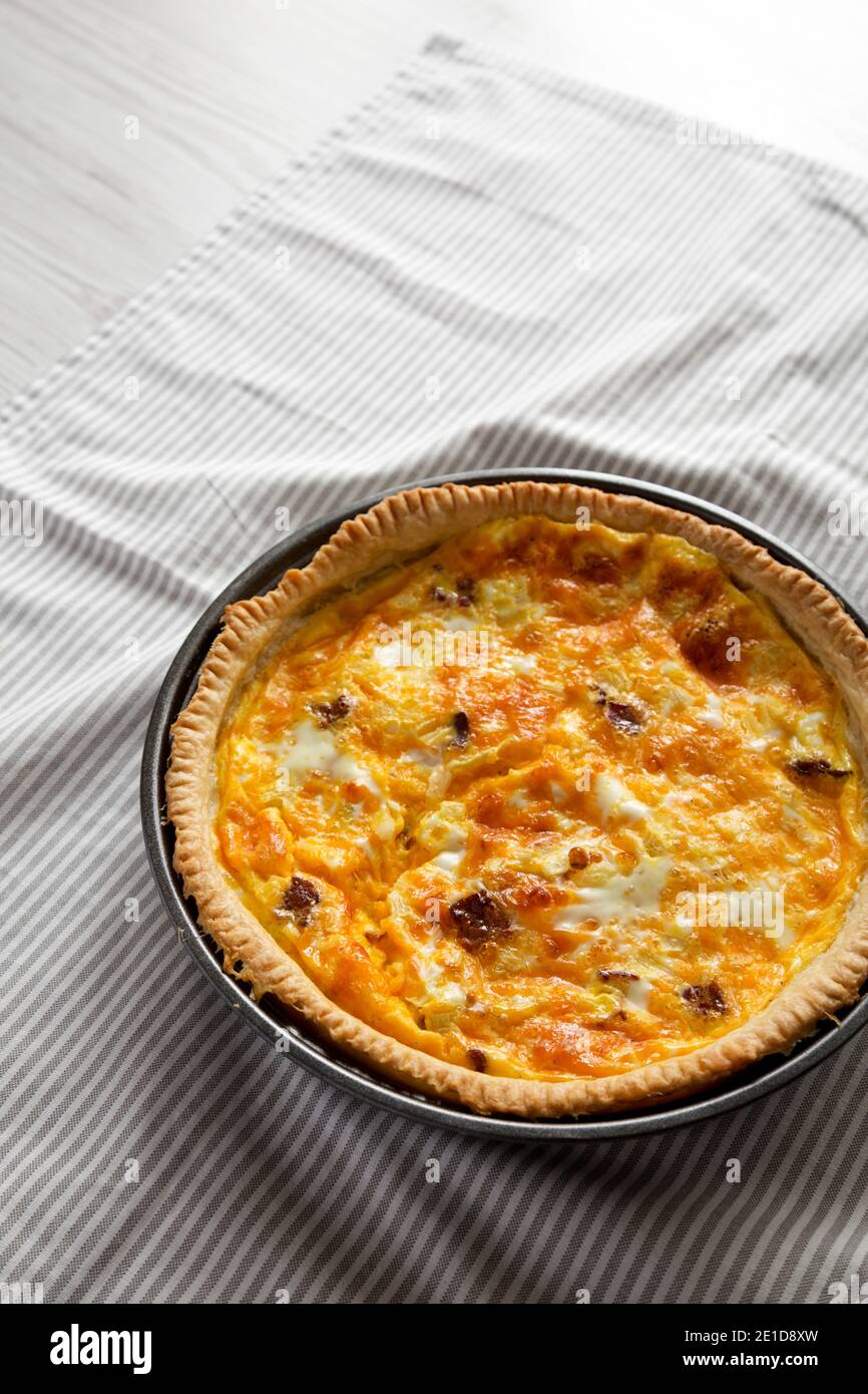 Homemade Bacon Quiche with Eggs and Cheddar Cheese on cloth, side view ...