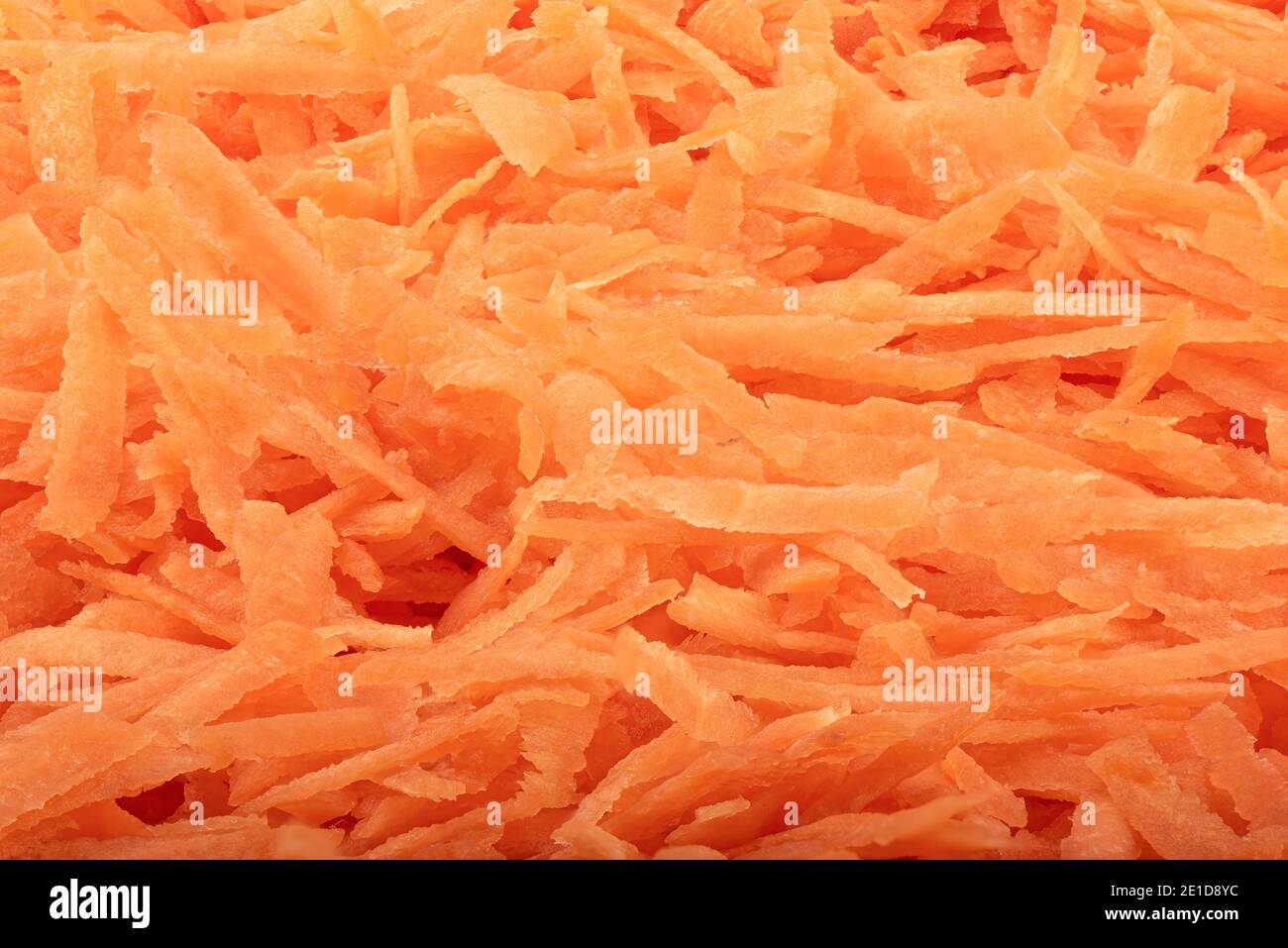 Full frame of a heap of grated carrots. The texture of grated carrots ...