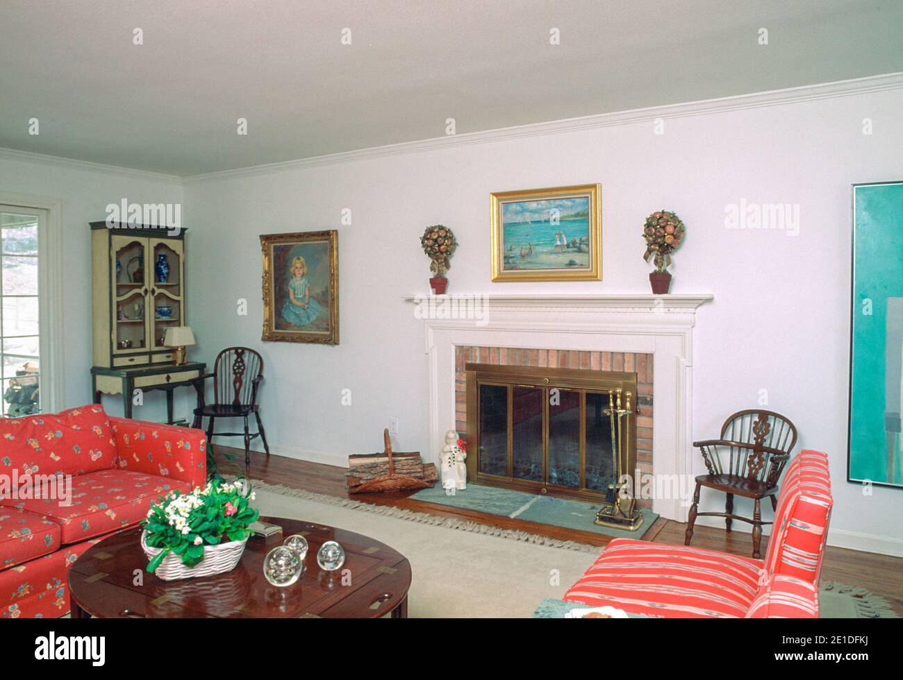 Early American style home has a fireplace and red sofas, USA Stock ...