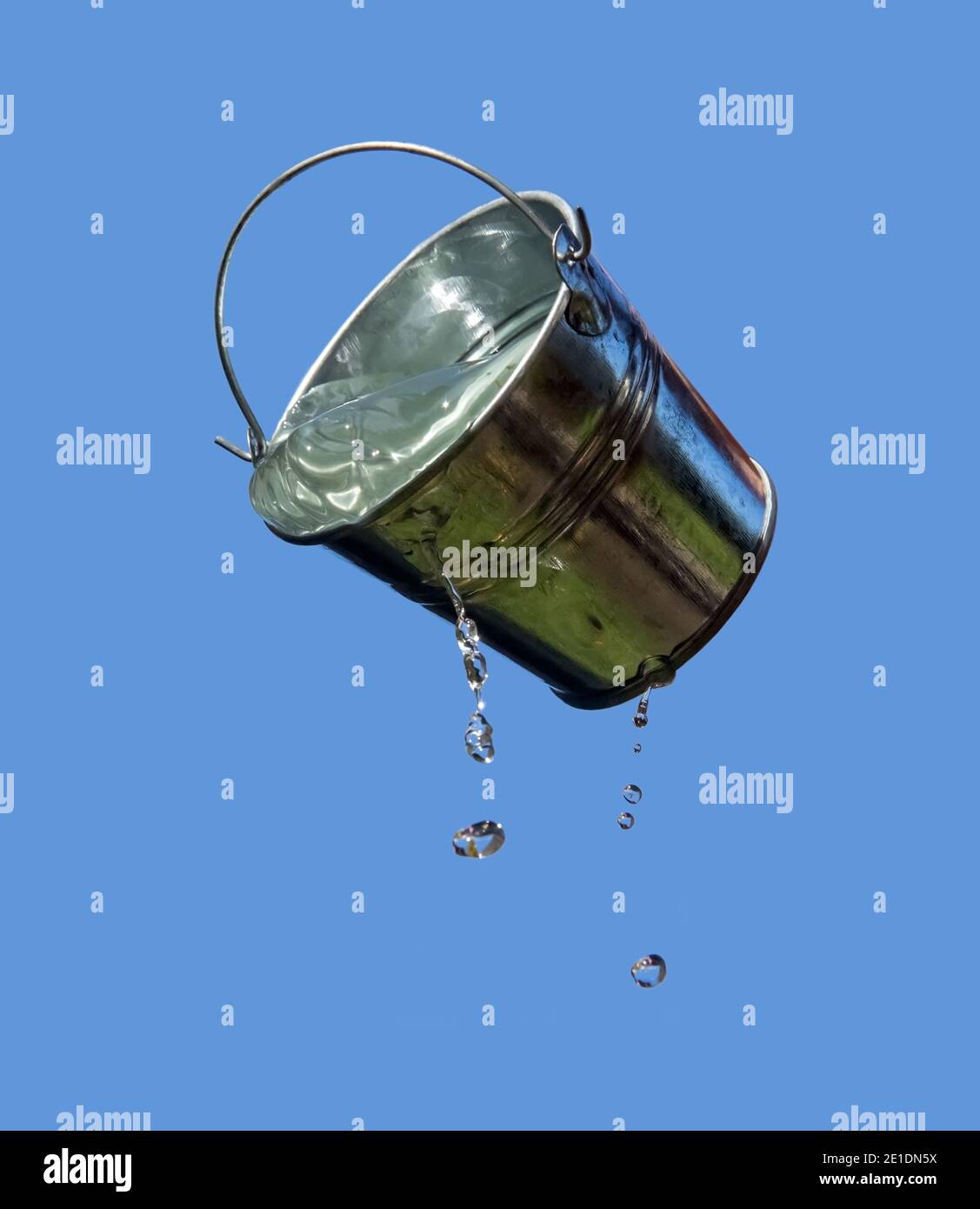 A falling buckets splashes water, on a background of blue sky Stock ...