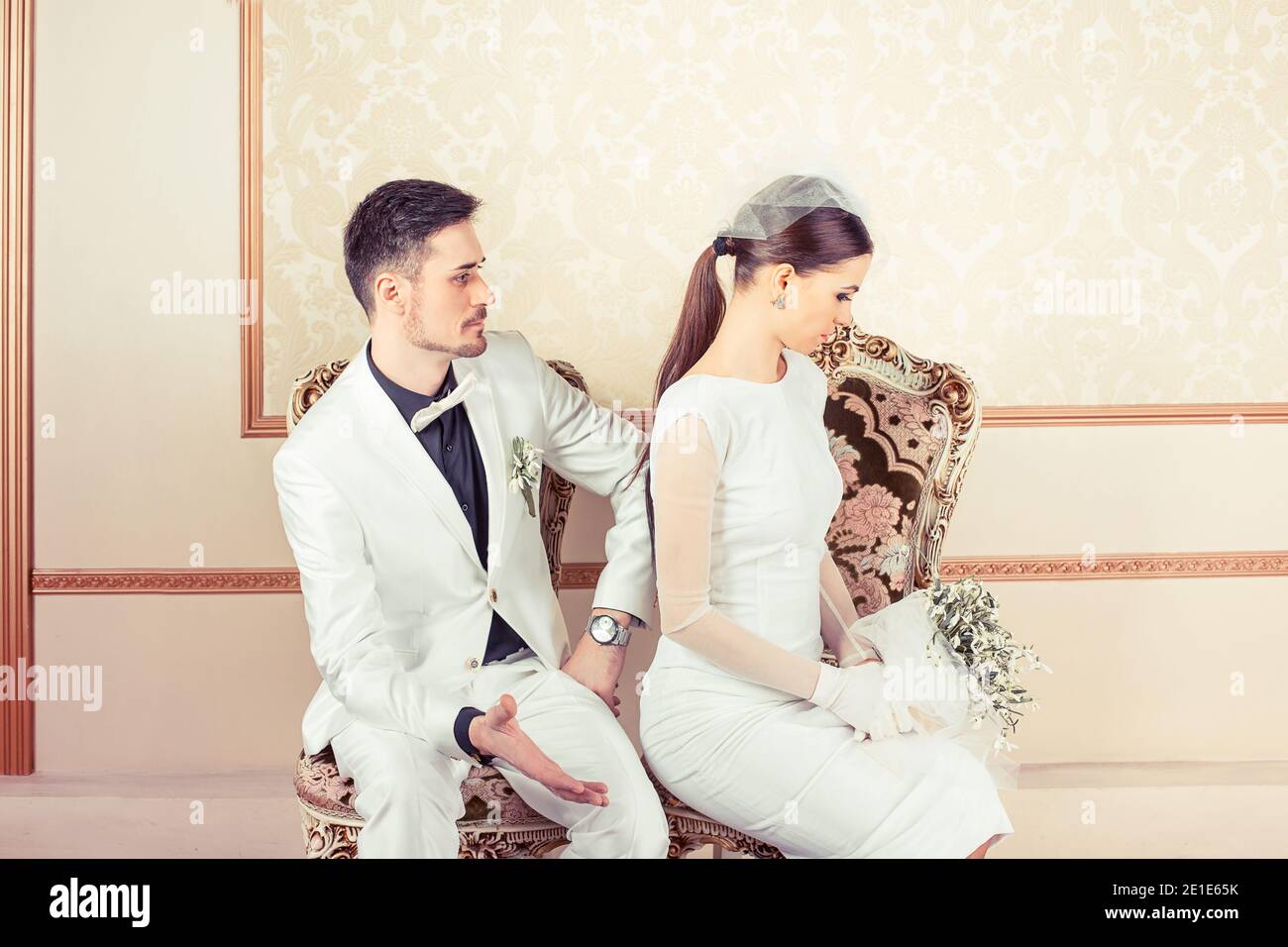 Angry young bride and groom, man and woman upset on each others sitting ...